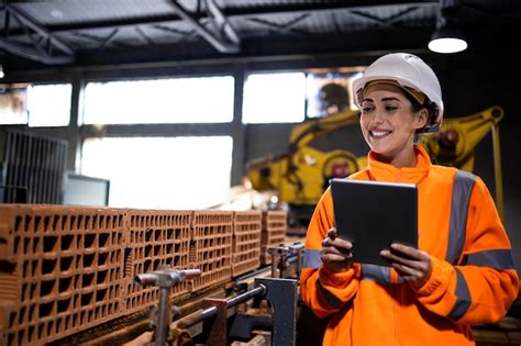 Premium Photo Production Line Female Worker Holding Tablet Computer And Checking Quality In