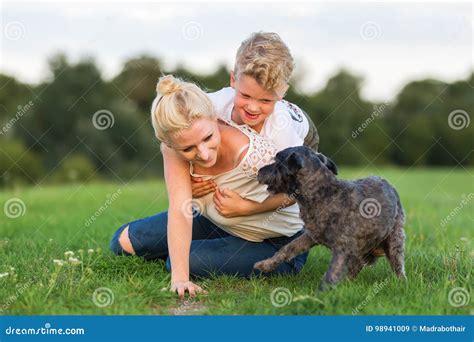 Kobiet Igraszki Z Jej Synem I Psem Na Trawie Obraz Stock Obraz złożonej z joyce igraszki