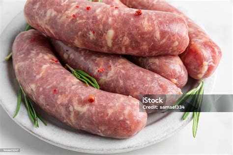 흰색 배경에 접시에 향신료와 로즈마리를 곁들인 생 소시지 또는 소세지 클로즈업 고기에 대한 스톡 사진 및 기타 이미지 고기 날것 독일 음식 Istock