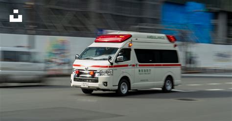 건물 옆 도로를 달리는 구급차 사진 Unsplash의 무료 도쿄 이미지