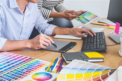 두 동료 창조적인 그래픽 디자이너 색상 선택에 노력 하 고 직장에서 그래픽 태블릿 컬러 선택 색칠 견본 샘플 차트에 그리기