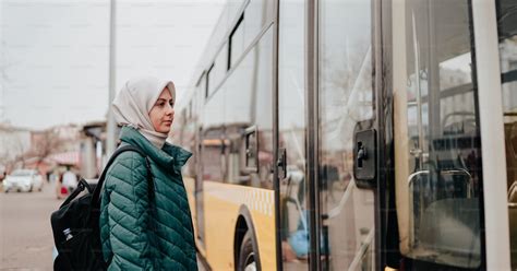 A Woman In A Hijab Stands In Front Of A Bus Photo Bus Image On Unsplash