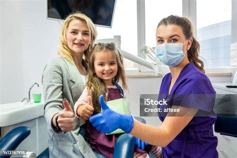 어린 소녀의 어머니와 치과 의사는 치과 치료 전에 어린 소녀를 진정시킵니다 치과에 대한 스톡 사진 및 기타 이미지 치과 아기 어머니 Istock