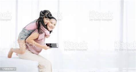 좋은 여자와 그녀의 어머니는 함께 즐길 수 있습니다 집에서 즐거운 시간을 보내고 있습니다 아이는 잠에서 깨어난다 아시아 가족 놀이 에 침대 에 이 침실 2명에 대한 스톡