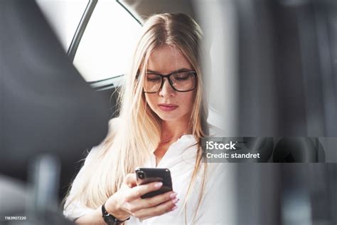 농축 된 모습 아름다운 금발의 소녀 앉아 에 이 새로운 차 와 현대 검정 인테리어 검은색에 대한 스톡 사진 및 기타 이미지