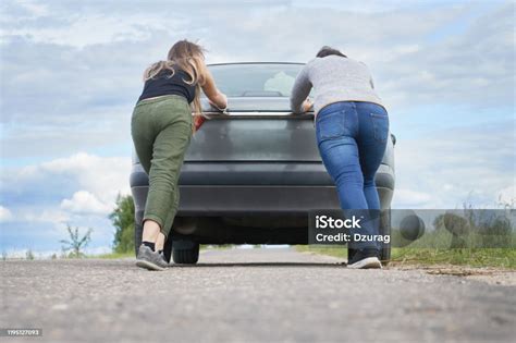 시골 길을 따라 가솔린이 다 소진된 차를 밀고 있는 두 소녀 밀기에 대한 스톡 사진 및 기타 이미지 밀기 차 깨짐