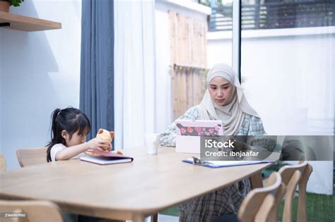 집에서 일하면서 딸의 숙제를 도와주는 엄마 교육 자료와 노트북이 있는 나무 탁자에 앉아 있는 모습 2 3 살에 대한 스톡 사진 및 기타 이미지 Istock