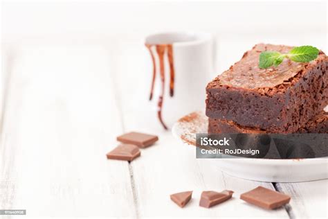 흰색 접시에 스택에 초콜릿 브라 우 니 정사각형 조각 장식 민트 잎과 흰색 빈티지 나무 바탕에 코코아 가루 미국의 전통적인 맛 있는 디저트 클로즈업 사진 갈색에 대한 스톡