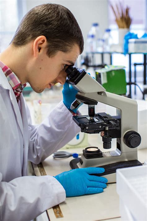 Man Using Microscope In A Lab Del Colaborador De Stocksy Mosuno Stocksy