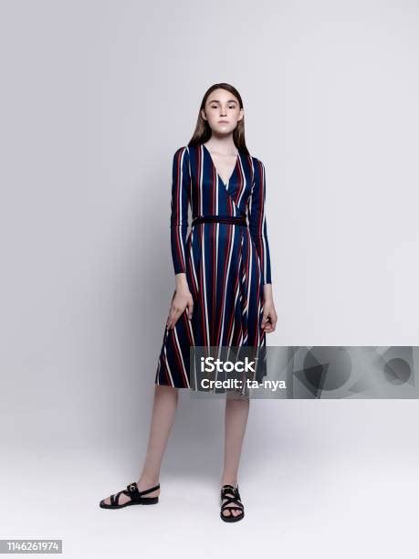 전체 길이 초상화 흰색 배경에 포즈 어두운 파란색 흰색과 빨간색 줄무늬 캐주얼 드레스와 샌들을 입고 아름 다운 어린 소녀 랩 원피스에 대한 스톡 사진 및 기타 이미지