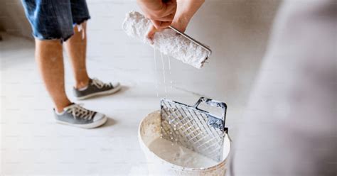 알아볼 수 없는 젊은 부부는 새 집에서 페인트 롤러를 사용하여 재미있게 벽을 칠합니다 집 개조 및 개조 개념 사진 Unsplash의 집 이미지