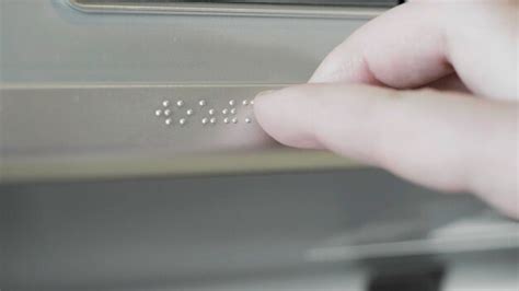 Premium Photo Close Up Of Male Hand Touching Braille On A Metal Sign