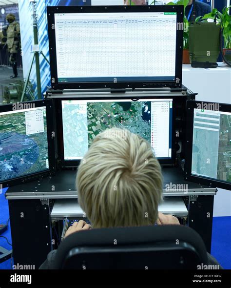 Young Man Sitting In Front Of Monitors And Working With Military