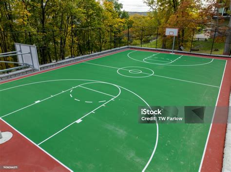 학교 운동장에서 녹색과 빨간색 야외 농구 코트의 항공 사진 법원에는 옹벽과 검은 색 비닐 코팅 체인 링크 울타리가 포함됩니다 코트 스포츠 경기장에 대한 스톡 사진 및 기타