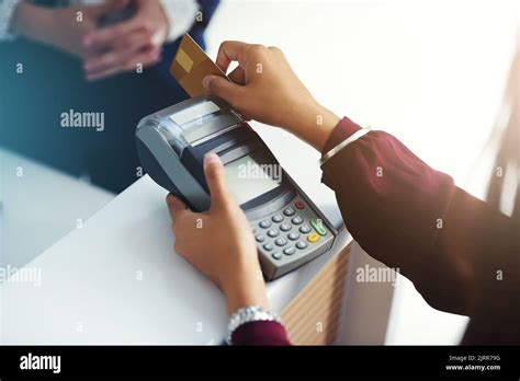 Settling A Charge By Card An Unrecognisable Person Swiping A Credit
