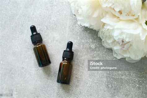 호박색 유리 아로마 오일 병과 돌 배경에 모란 꽃 플랫 레이 상단 보기 허브 화장품 천연 유기농 미용 제품 에센셜 오일 포장 디자인 작은 병에 대한 스톡 사진 및 기타