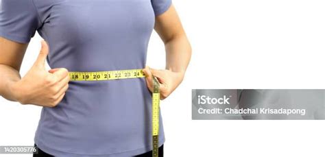 운동복을 입은 클로즈업 여성 손은 허리 주위를 측정하기 위해 줄자를 사용합니다 건강한 영양과 체중 감량 개념 스튜디오 조명이있는 흰색 배경의 초상화 다이어트에 대한 스톡