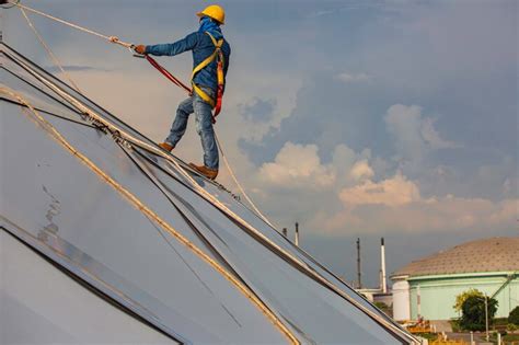 남성 노동자 로프 접근 높이 안전 매듭 안전 하네스와 연결하여 지붕 건설 현장 오일 탱크 돔에 클리핑 프리미엄 사진