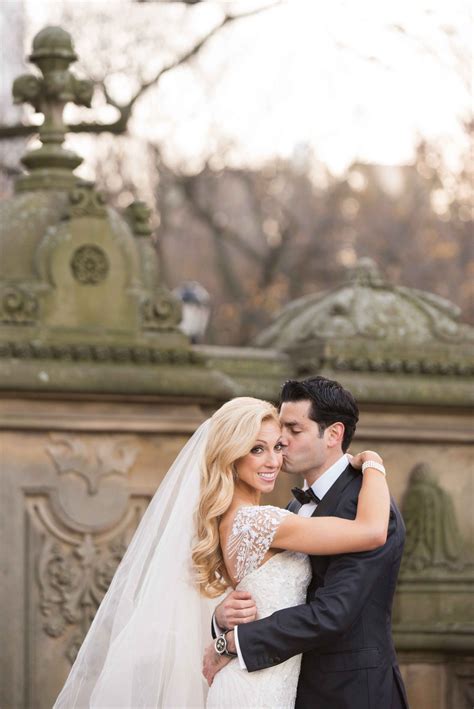 Groom Kisses Bride On Cheek In Portrait
