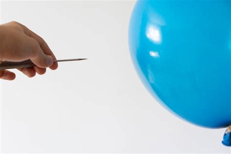 Premium Photo A Needle Blowing Balloon As The Concept Of Economy Risk