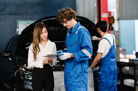 자동차 서비스 및 자동차 정비 개념 수리 차고에서 점검 목록을보고 수리 품목을 수리 한 아시아 여성 고객과 자동차 기술자 남자 3 명에 대한 스톡 사진 및 기타 이미지