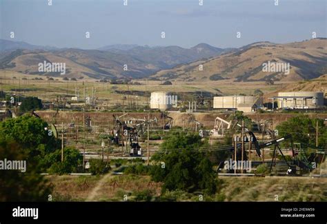 Landscape With Hills And Pumpjacks Or Walking Beam Pumps And Crude Oil