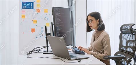 Young Adult Asian Female Software Developer Coding Program On Desktop Computer Woman Work From
