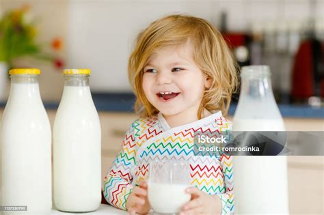 사랑 스러운 유아 여자 아침 식사 암소 우유를 마시는 병이 많은 귀여운 아기 딸 건강 한 아이 칼슘 소스로 우유를가지고 아침에