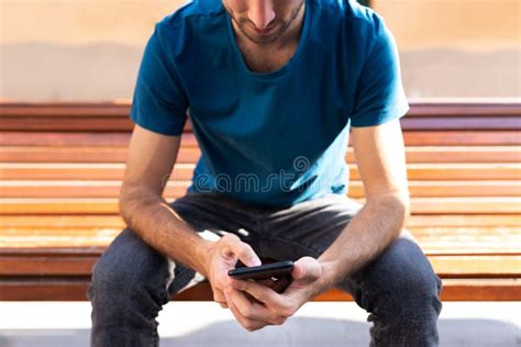 Young Man Send Text Message Using Smartphone Relaxing Sitting On A