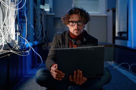A System Administrator Working In Server Room Using Laptop Stock Image