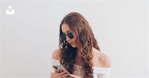 흰색 탱크 탑과 파란색 데님 청바지를 입은 여자가 주황색 의자에 앉아 있다 사진 Unsplash의 무료 여자 이미지