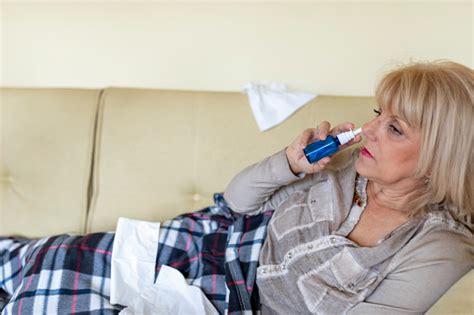 계절 독감 바이러스를 가진 아픈 수석 여자는 비강 스프레이를 사용하고 있습니다 55 59세에 대한 스톡 사진 및 기타 이미지