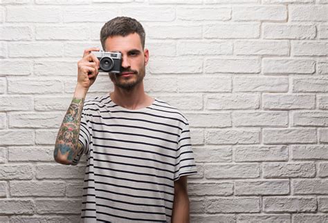스마트 얼굴 심각한 생각에 자신감이 식 흰색 벽돌 벽을 통해 서 빈티지 카메라를 들고 젊은 남자 감정에 대한 스톡 사진 및 기타 이미지 Istock