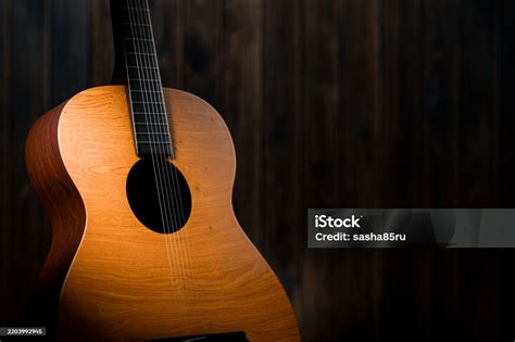 디자인 포스터 공지를 위한 빈 공간 클래식 어쿠스틱 기타가 바의 나무 벽 근처에 서 있습니다 소박한 인테리어의 악기 기타 레슨 3d 렌더링 Eurovision Song