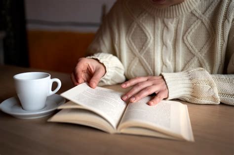 Free Photo Person In A Cafe Reading A Book While Having Coffee