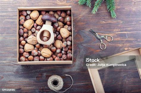 호두 헤이즐넛 버섯 모양의 호두까기 인형 가위 황마 실 소박한 나무 테이블에 두 종류의 견과류가 있는 판지 상자 건강한 크리스마스 선물 개념 0명에 대한 스톡 사진 및 기타