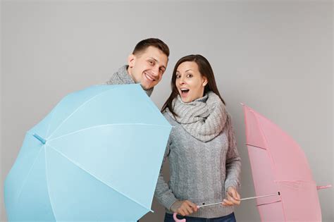 회색 벽 배경 스튜디오 초상화에 고립 된 우산 아래 함께 회색 스웨터 스카프에 커플 여자 사람입니다 건강 한 생활 습관 병 아픈 질병 치료 추운 계절 개념 복사 공간을 모의