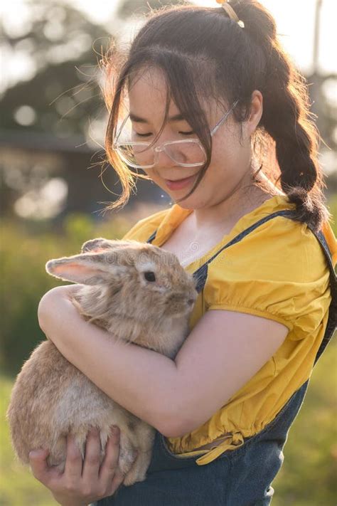Woman Holding Cute Fluffy Bunny On Park Outdoors Friendship With Easter Bunny Stock Image