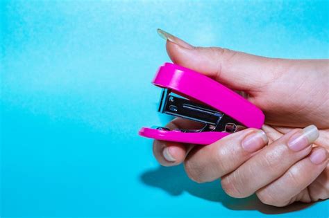 Premium Photo Young Latin Womans Hand With Long Fingernails Holding A Small Pink Stapler