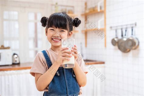 在家里厨房里拿着一杯牛奶的亚洲可爱小孩的图片 包图网企业站