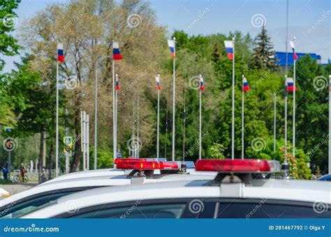 Police Car Flashing Light. in the Background, the Flags of Russia are ...
