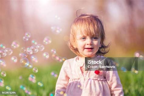 귀여운 웃는 아기 소녀는 녹색 들판에서 비누 거품으로 놀고 있습니다 유아에 대한 스톡 사진 및 기타 이미지 유아 비누 거품 야외 Istock