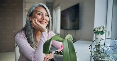 기하학적 유리 즙이 많은 테라리움으로 창턱에 손을 대고 웃고 있는 매력적인 여성 사진 Unsplash의 기쁨 이미지