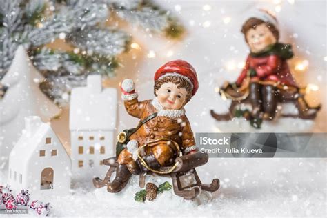 아름 다운 눈 덮인 배경에 나무 썰매에 아이의 귀여운 모습이 있는 복고풍 크리스마스 카드입니다 소년 B가 눈덩이를 하고 있다