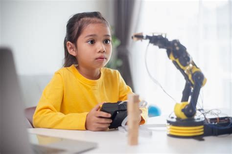 Stem 교육 개념 아시아 학생들은 로봇 팔을 Stem 수학 공학 과학 기술 컴퓨터 코드로 아이들의 개념을 로봇 공학으로 코딩하여 집에서 배웁니다 프리미엄 사진