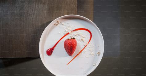 설탕으로 덮인 딸기를 얹은 하얀 접시 사진 Unsplash의 크림 이미지