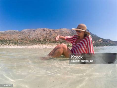 발로스 해변의 얕은 바닷물에서 태양을 즐기는 밀짚 모자를 가진 행복한 여성 크레타 그리스 관광에 대한 스톡 사진 및 기타 이미지 Istock