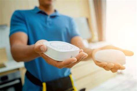 A Technician Installs A Security Alarm Siren And Motion Sensor Detector