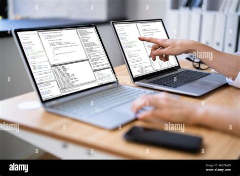 Programmer Woman Coding On Multiple Computer Screens Stock Photo Alamy