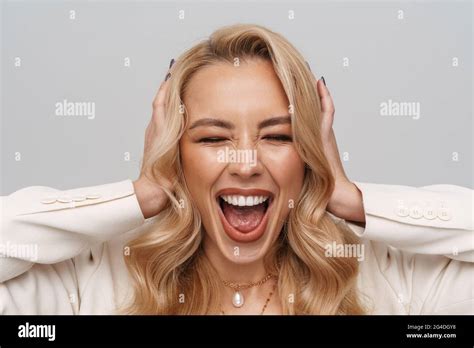 Beautiful Excited Girl In Jacket Screaming While Grabbing Her Head
